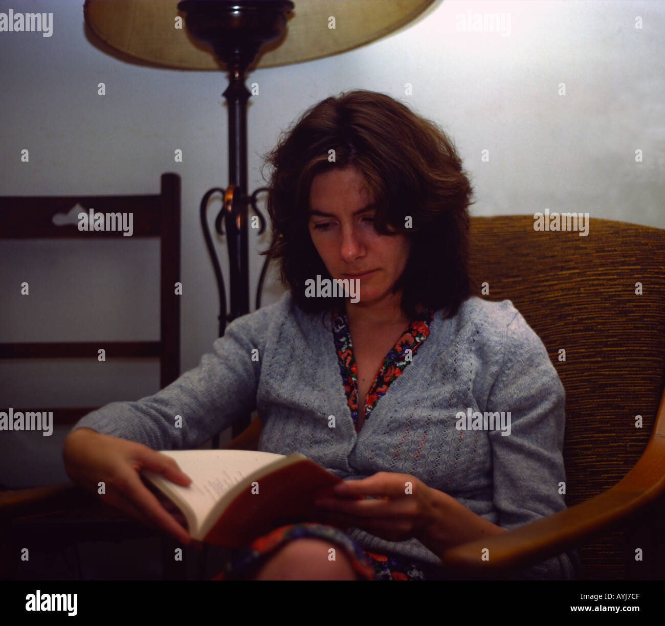 Girl reading under standard lamp Stock Photo - Alamy