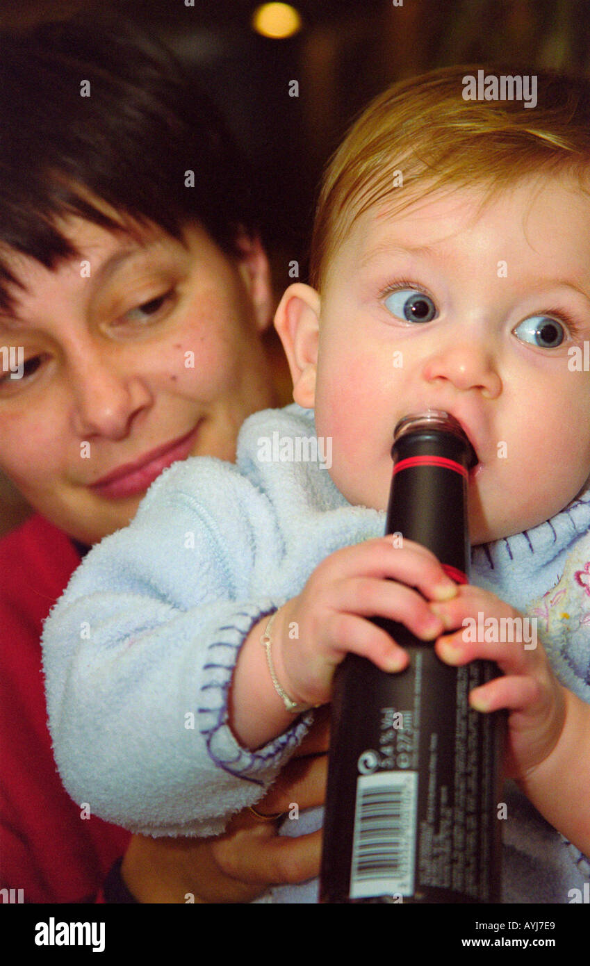 Baby is holding a bottle of beer Stock Photo - Alamy