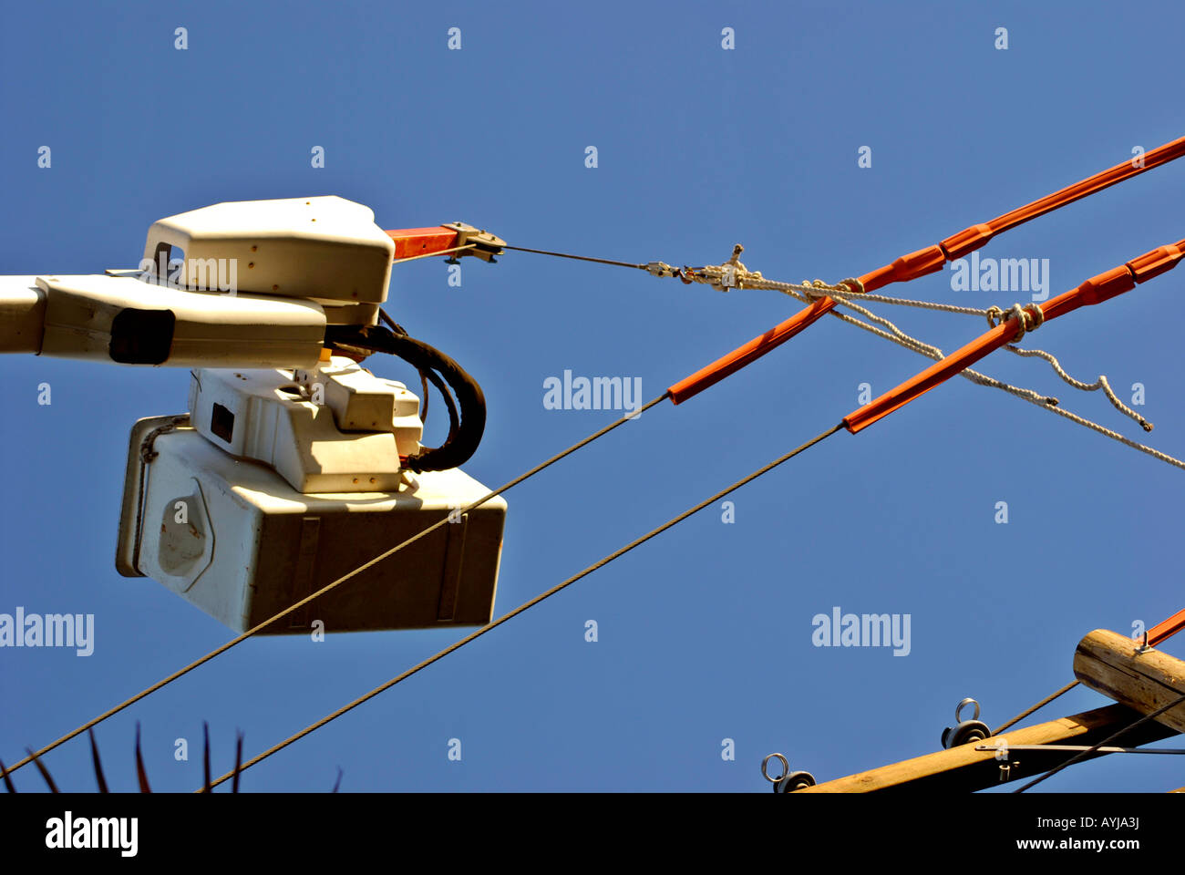 Boom crane secures power lines with a rope after being removed from a ...