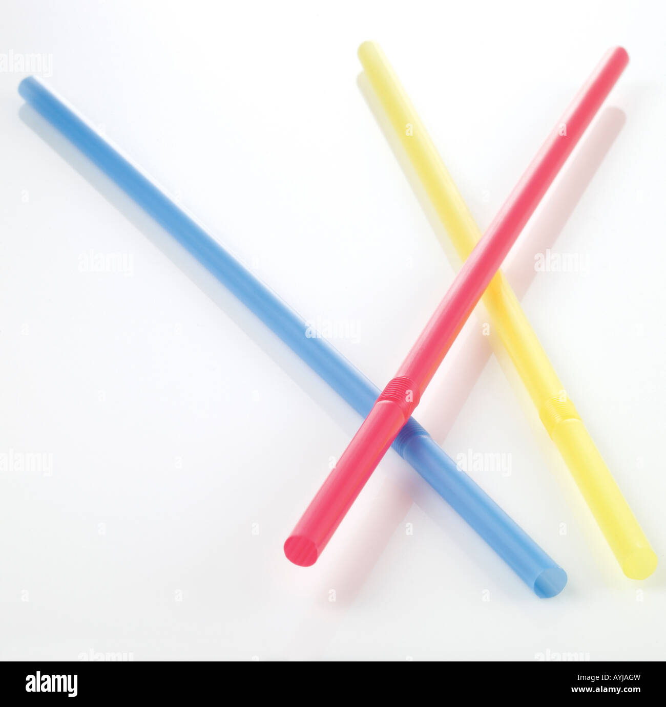 Studio shot of 3 straws on white. One red, One blue and one yellow ...