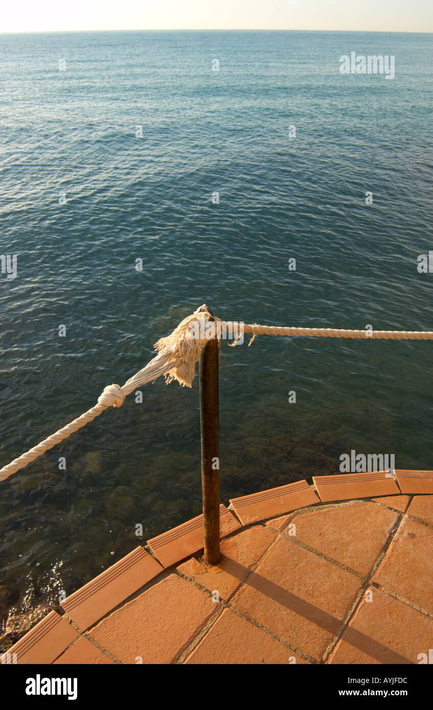 tiled edge of a promenade cordoned off with rope by the mediterranean ...