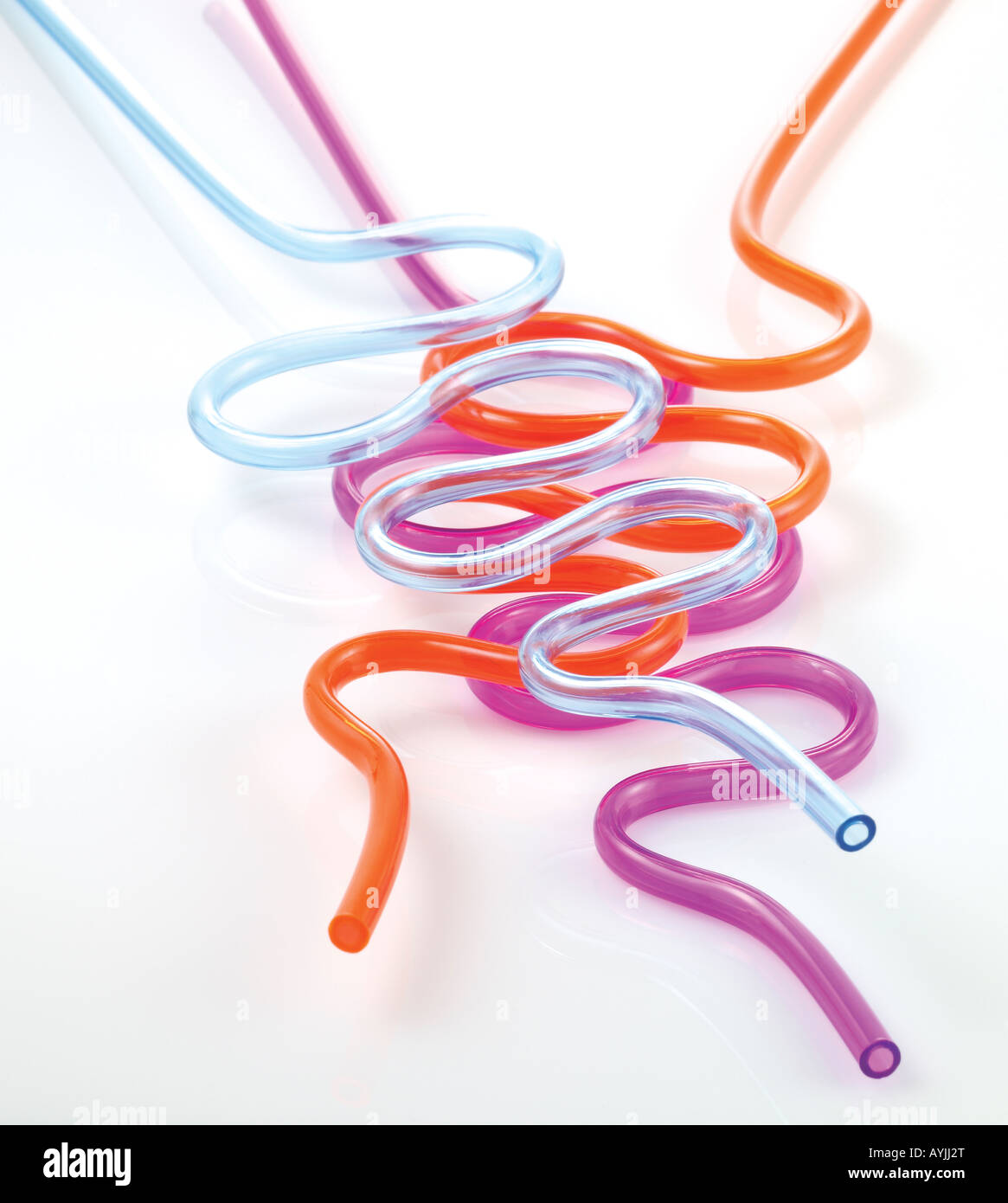 Studio shot of three curly straws on white. One blue, one purple, one ...