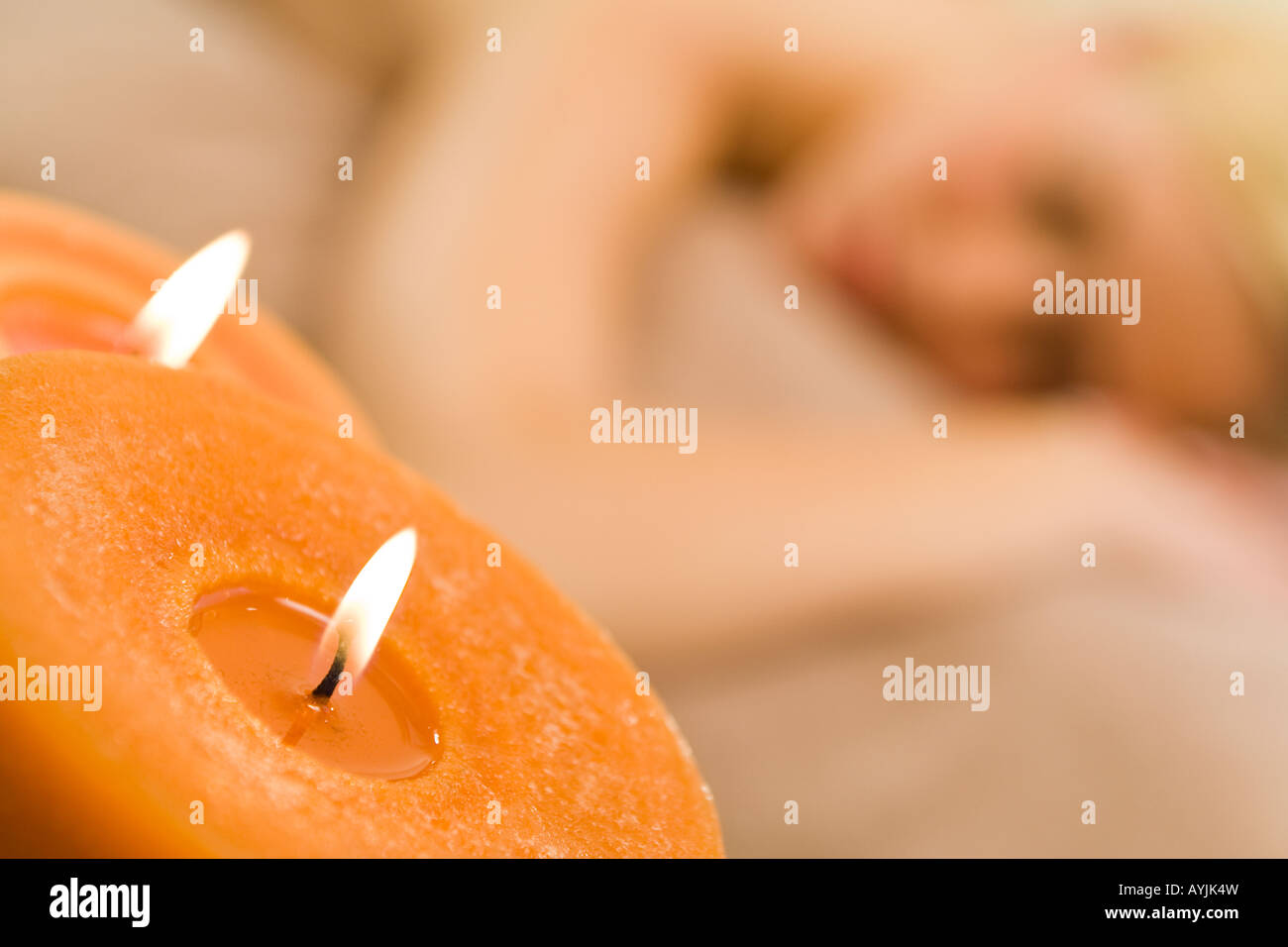 Concept shot showing candles in focus in the foreground while a young ...