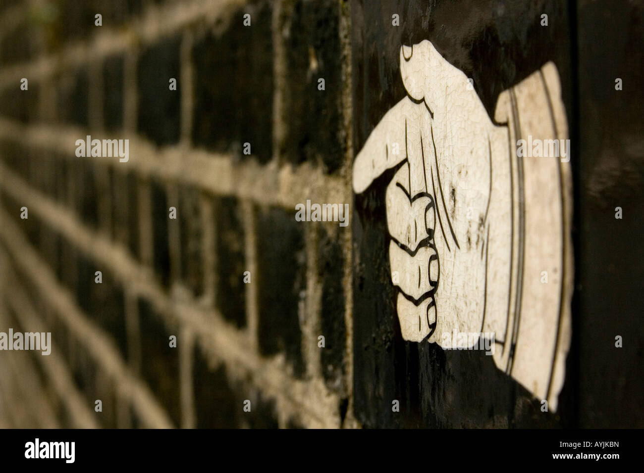 A finger pointing directions with hand from street sign on brick wall ...