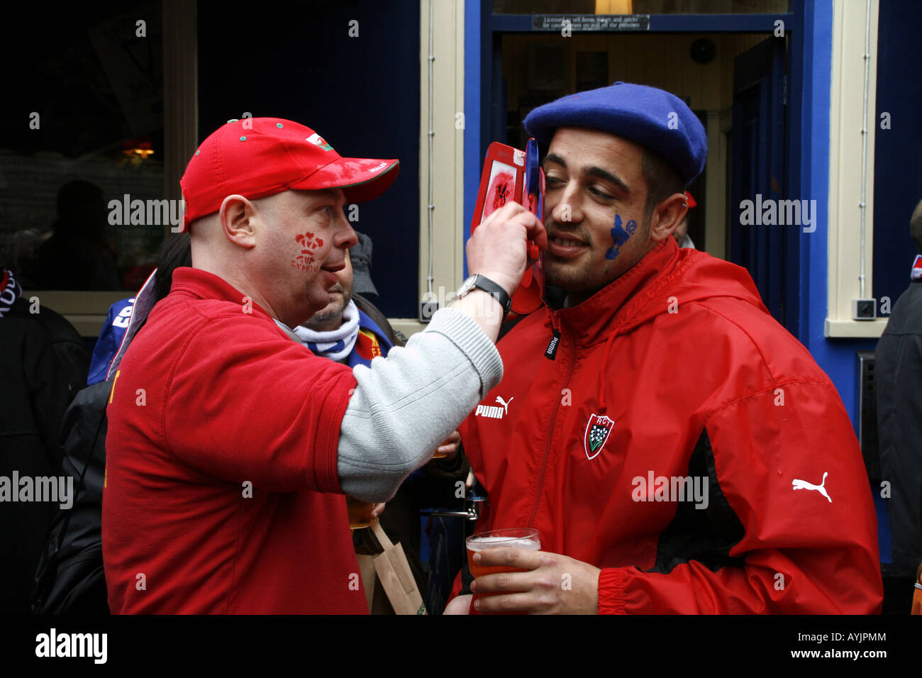 Welsh fan applies face paint to a French rugby supporter in Cardiff for ...