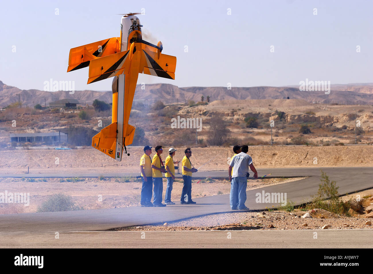A group of men operating a radio controlled model airplane in the Arava ...