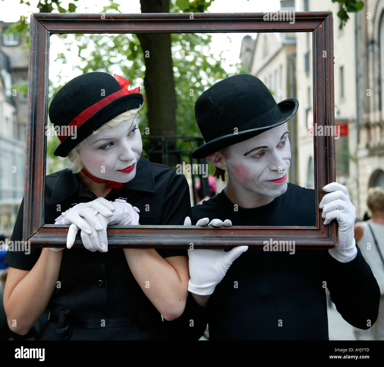 Street Performers looking sideways through a picture frame during ...