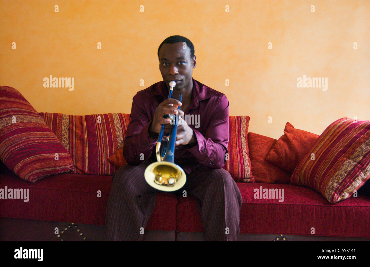 Trumpet Player on red sofa Stock Photo - Alamy