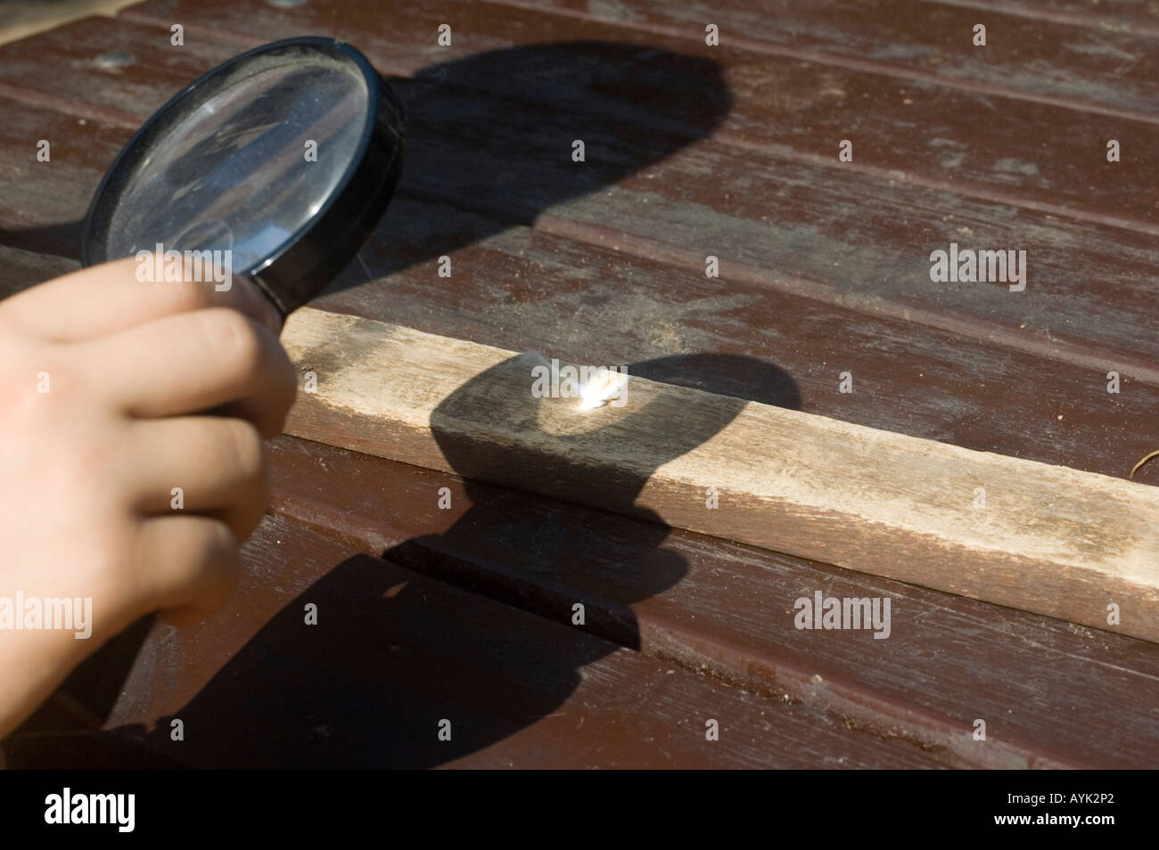Magnifying glass used to burn wood Stock Photo - Alamy
