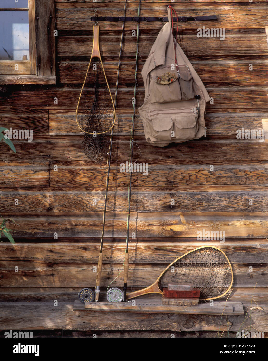 Fly fishing rods nets and fly boxes and fishing vest hanging on outside ...