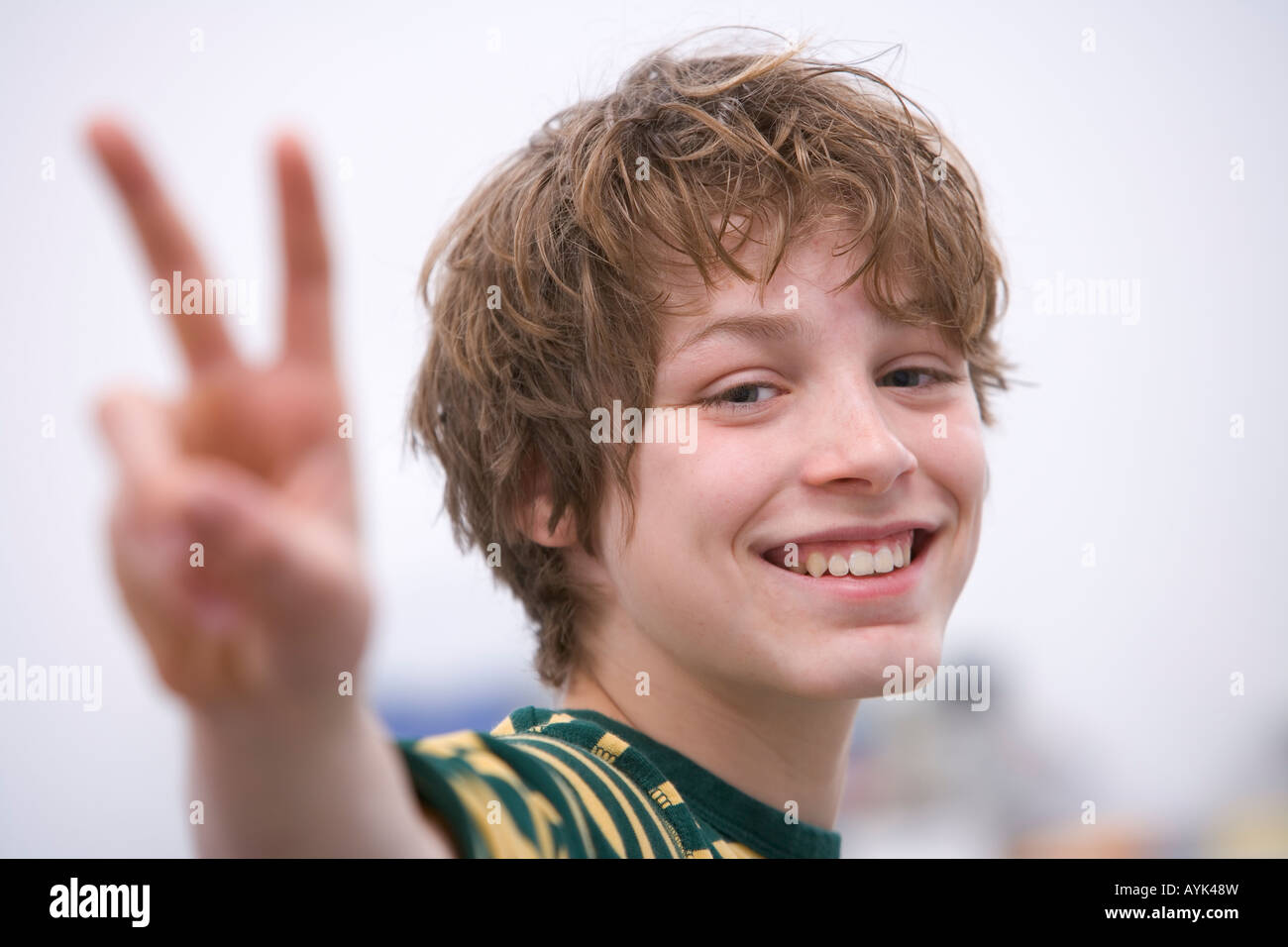 Teenage boy makes a V sign Stock Photo - Alamy