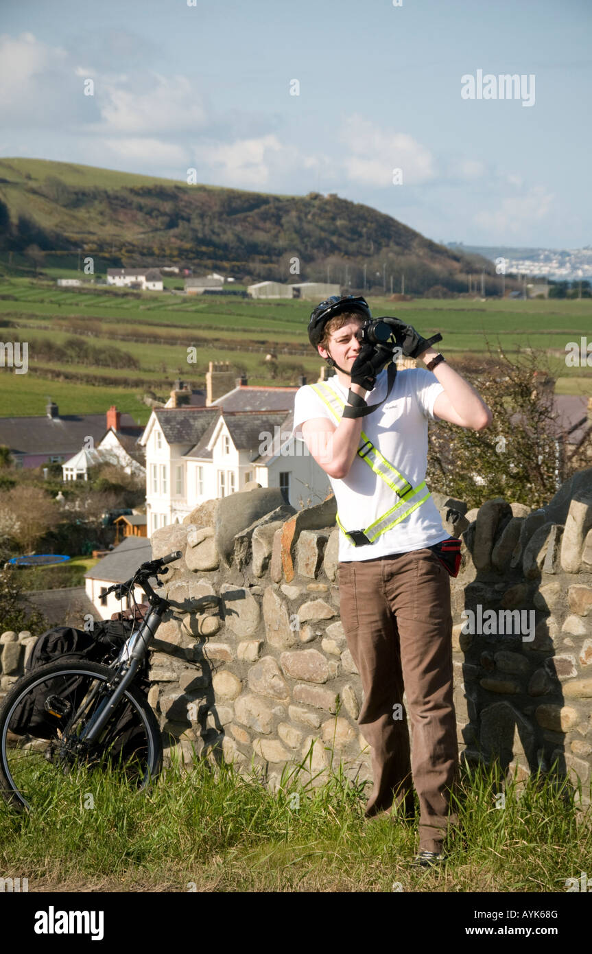 Young male cyclist taking photograph of Aberarth village on the ...