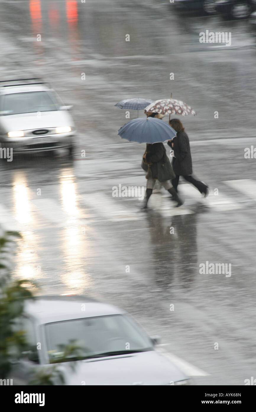 people with umbrellas crossing road in rain Stock Photo - Alamy