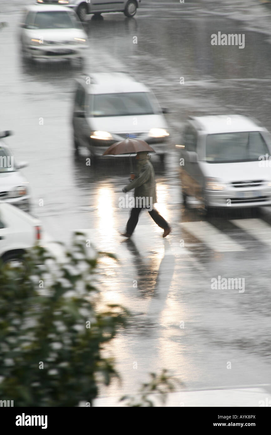 man with umbrella crossing road in rain Stock Photo - Alamy