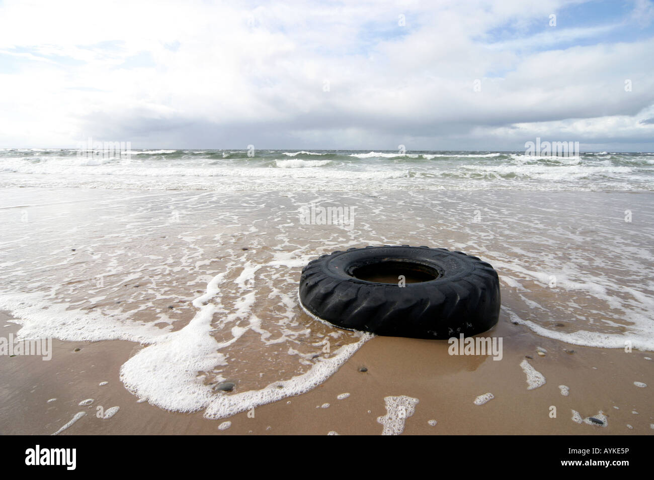 The sea tide washes round an abandoned tyre Stock Photo - Alamy
