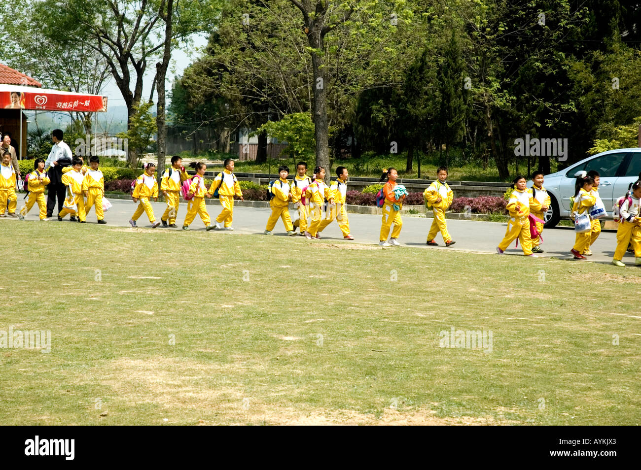 An orderly class of young Chinese schoolchildren in yellow school ...