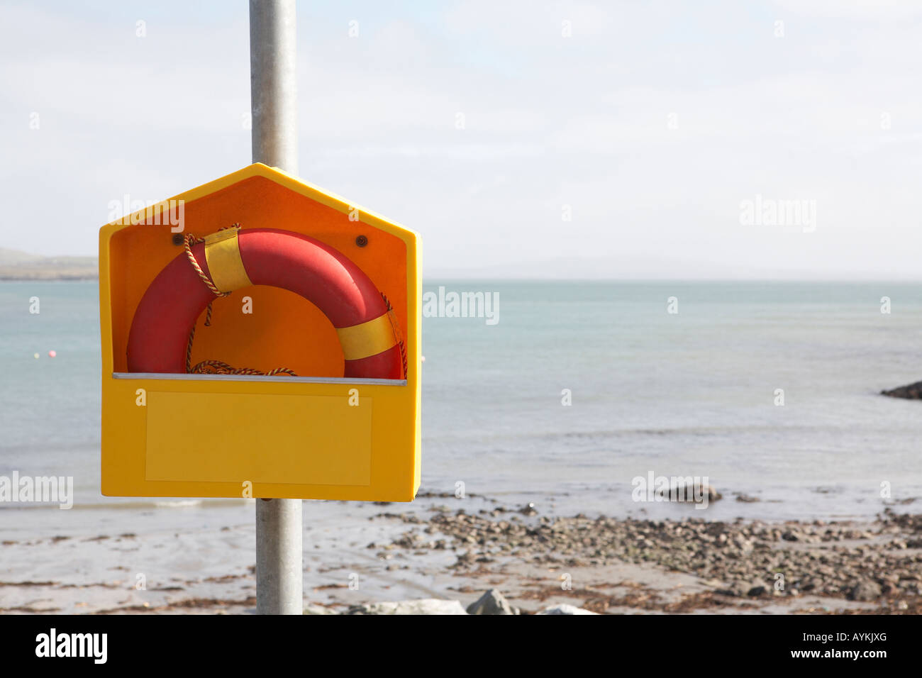 Life ring on post at waters edge Stock Photo - Alamy
