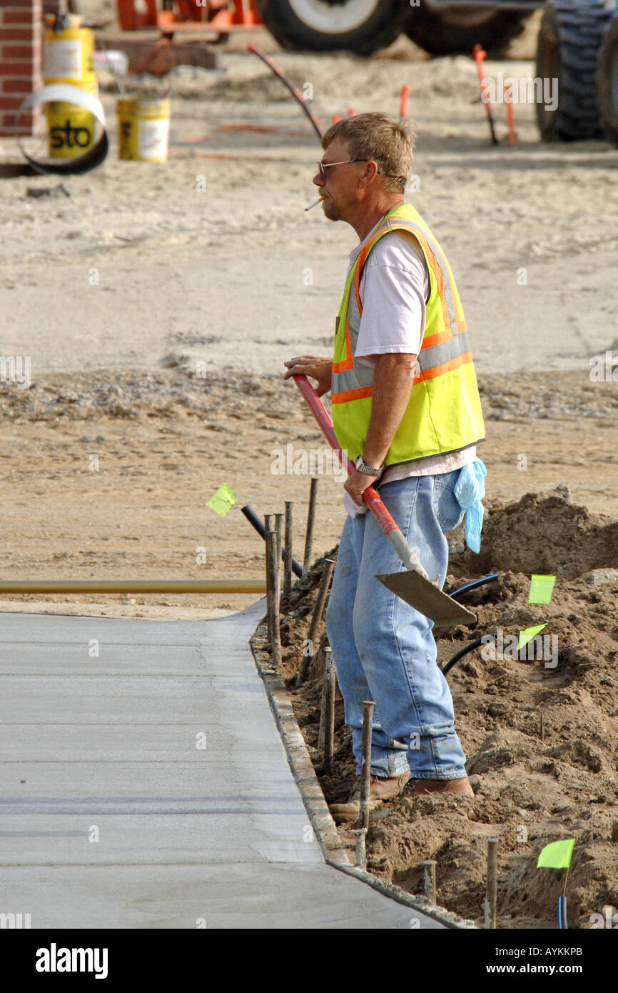 Construction worker leveling out a wet cement pathway Stock Photo - Alamy