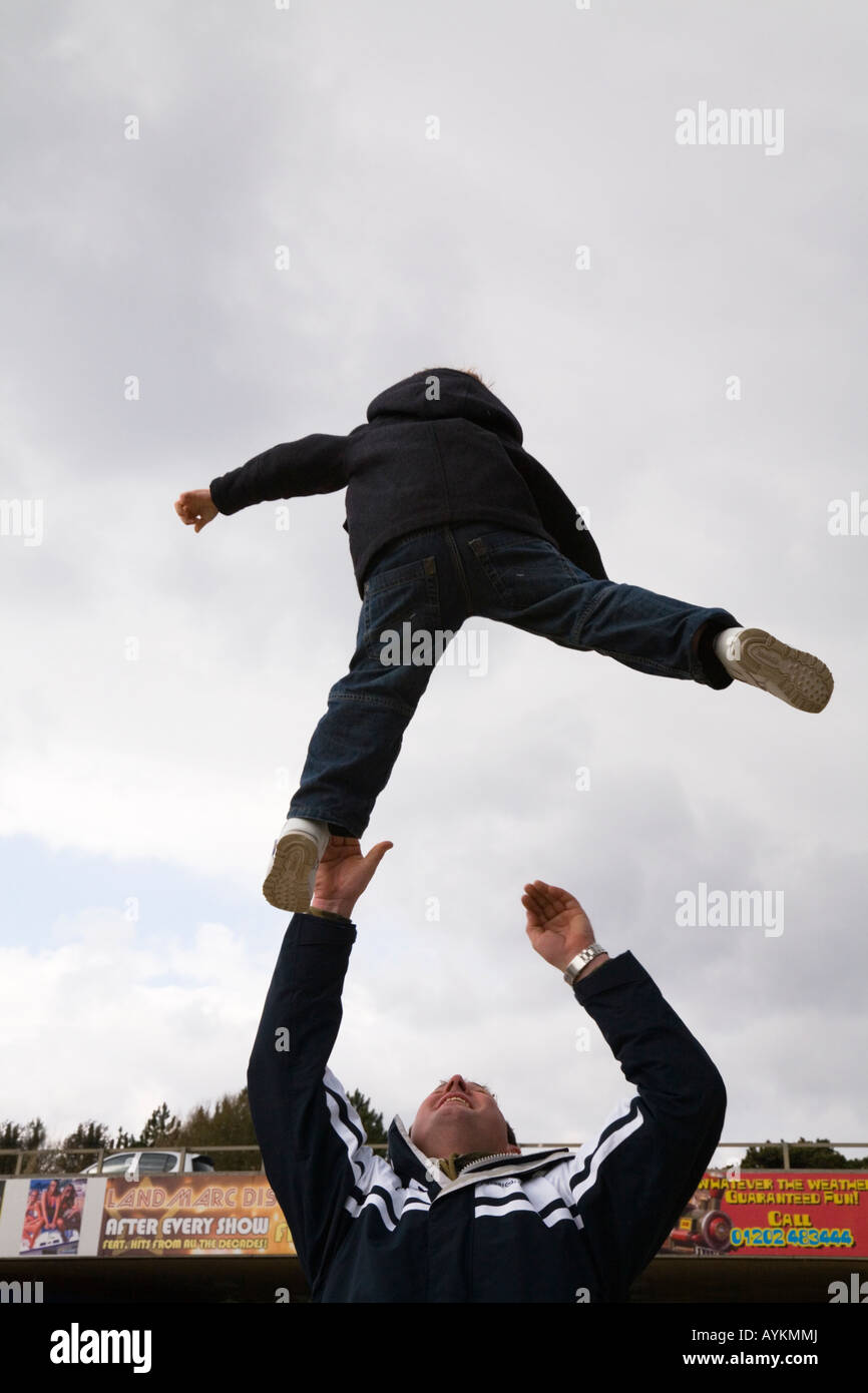 A father throws his young boy in the air and catches him Stock Photo ...