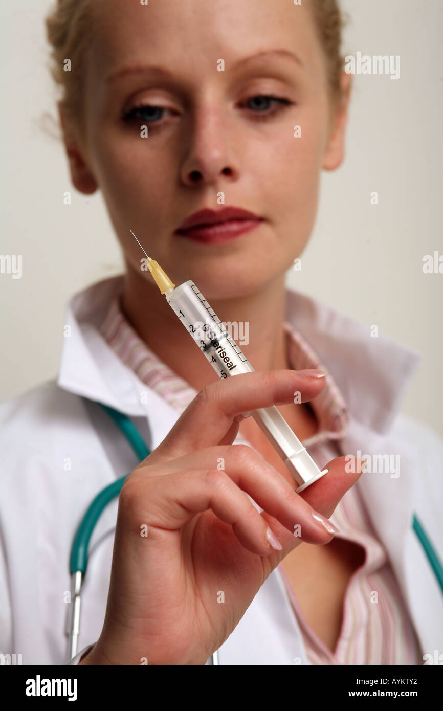 Female doctor in white coat and syringe Stock Photo - Alamy
