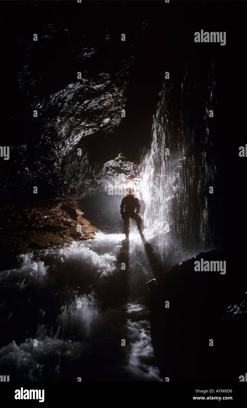 Caver exploring underground river in La Cuerva del Agua in the Picos de ...