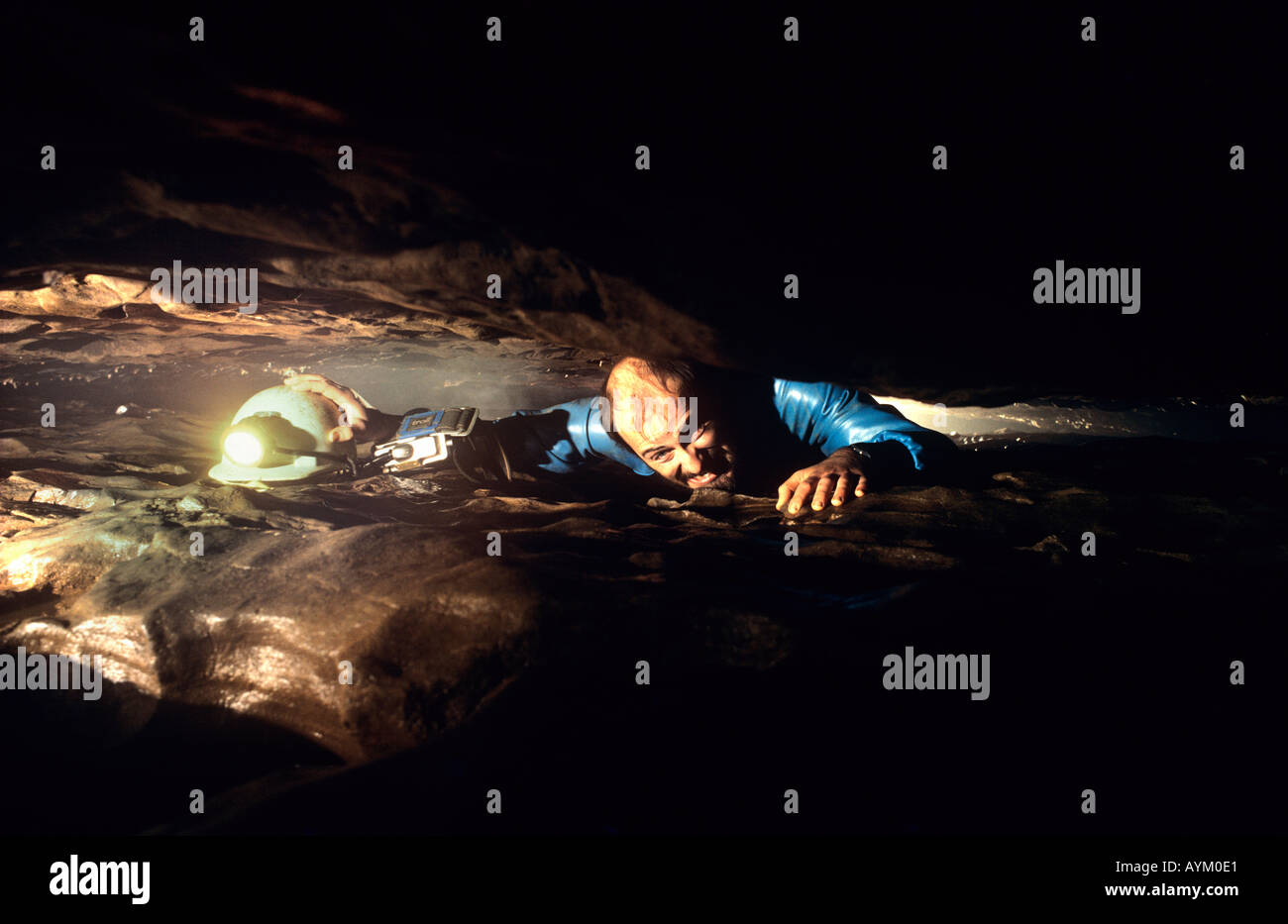 cave explorer squeezes through tight bedding plane in Ogof Ryhd Sych ...