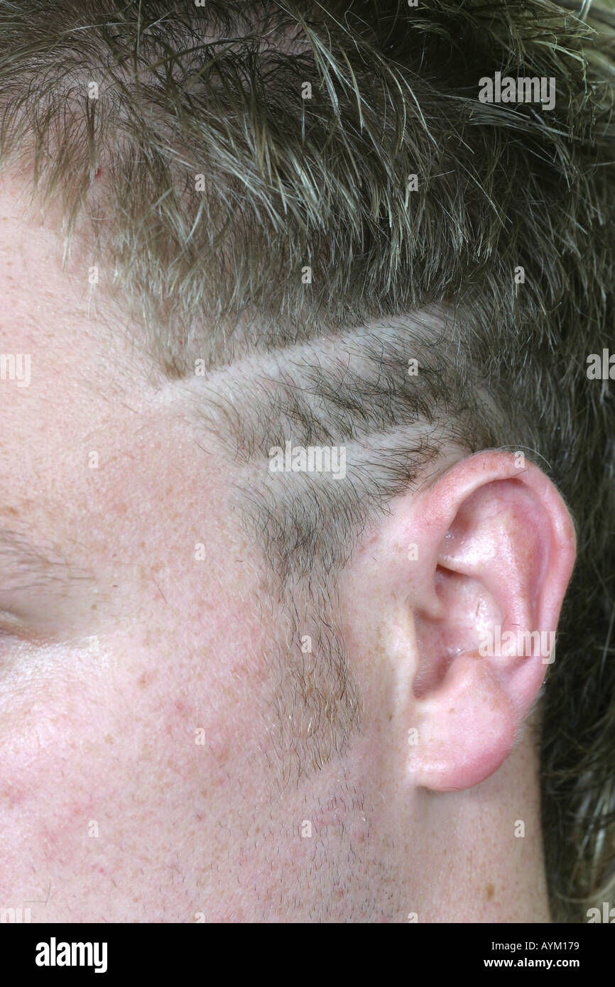 modern hair style with lines shaved above ears Stock Photo - Alamy