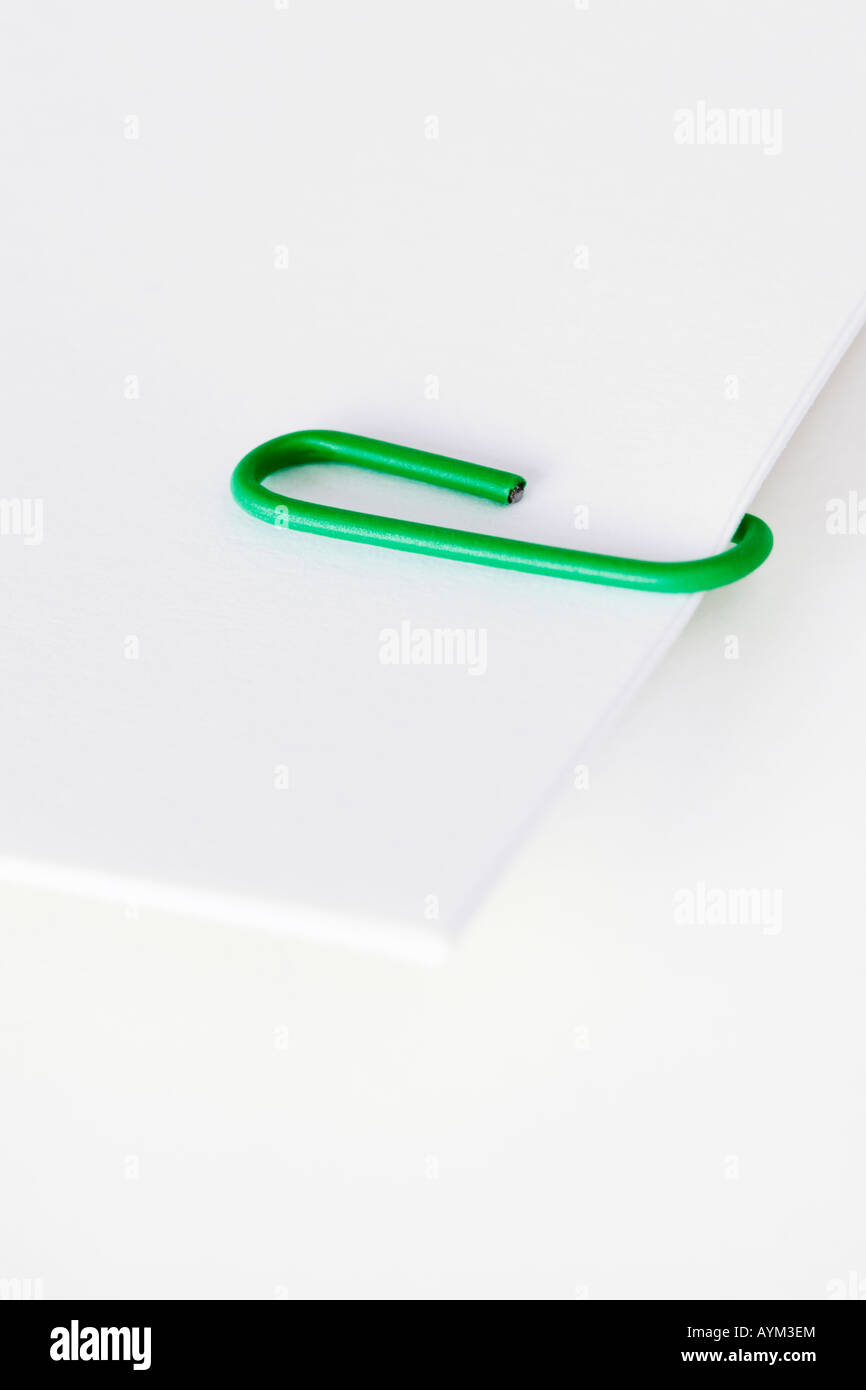 Green Paper clip on white paper close up Stock Photo - Alamy