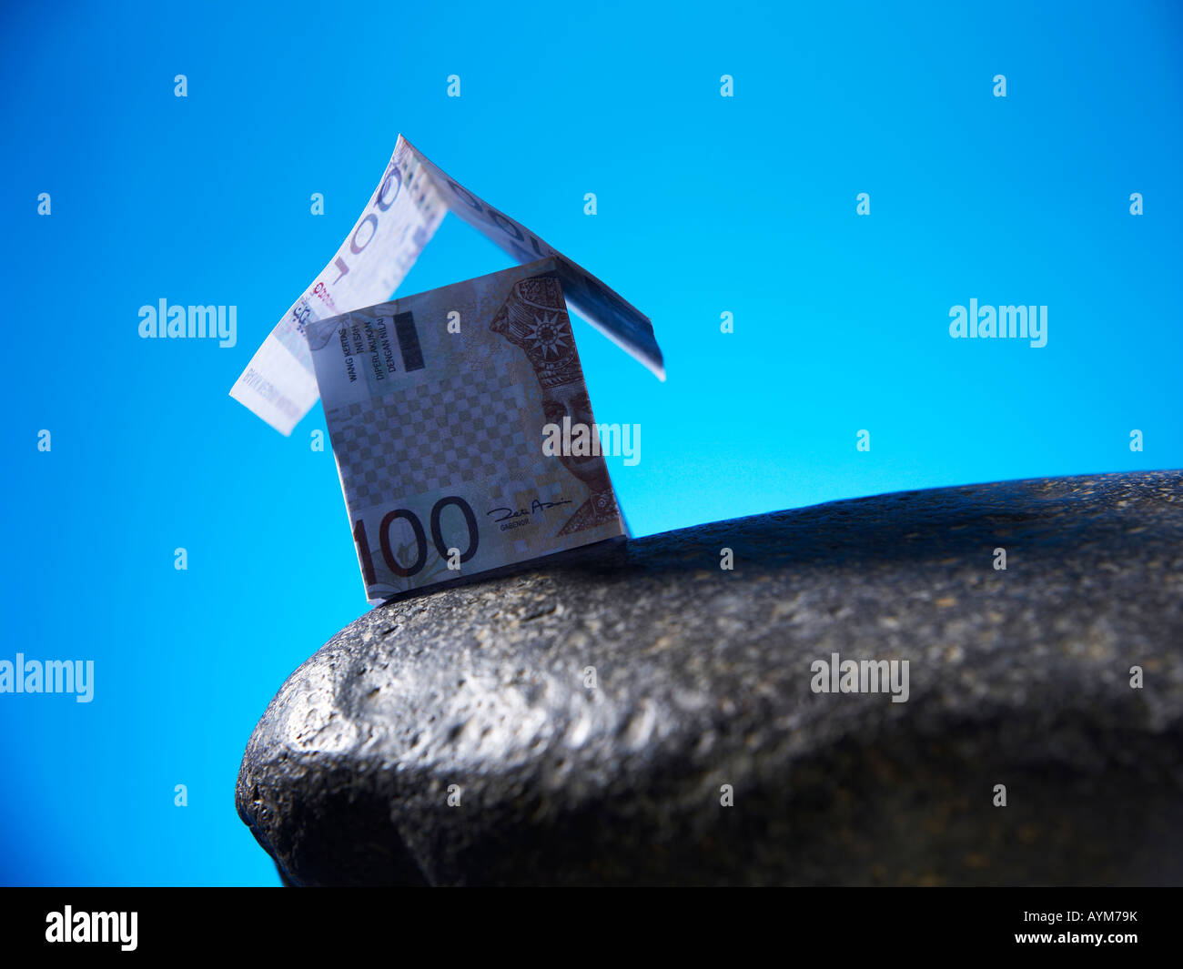 Placing folded ringgit malaysia on the edge of a rock Stock Photo - Alamy