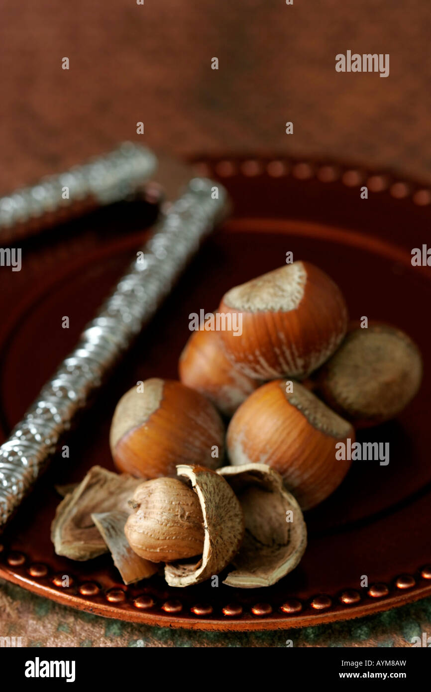 Hazelnuts and nutcracker on a red plate Stock Photo - Alamy