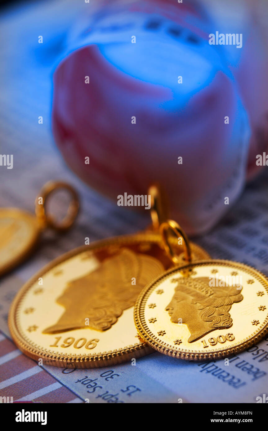 Stack of chinese gold coin with a rolled apper note, blue light on the ...