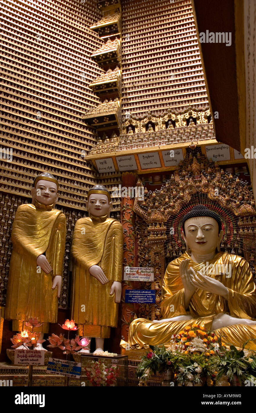 A Buddha image and two disciples with halos backed by thousands of ...