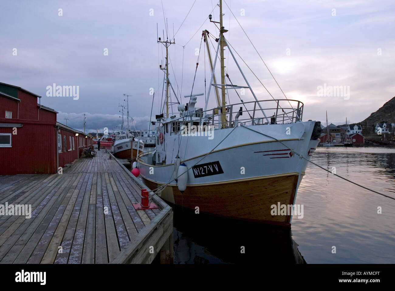 Fishing boat alongside old wooden quay at Ballstad, Lofoten, Norway ...