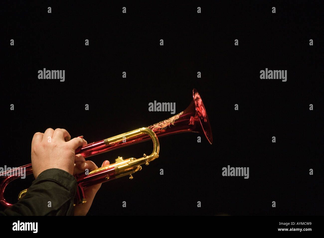detail of man playing a red trumpet on a black background Stock Photo ...