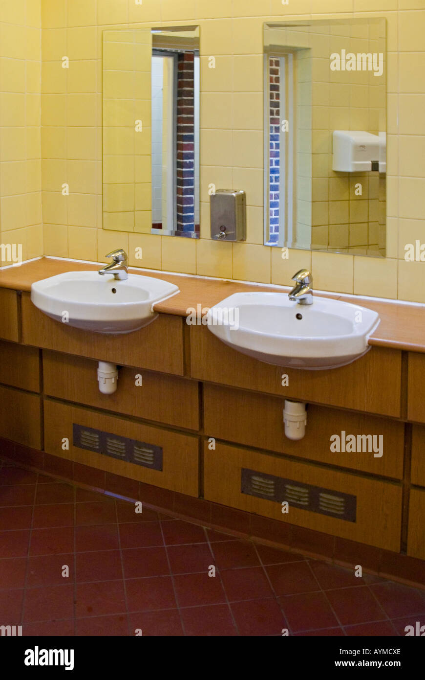 Two wash basins and mirror in a clean modern men's toilet Stock Photo ...