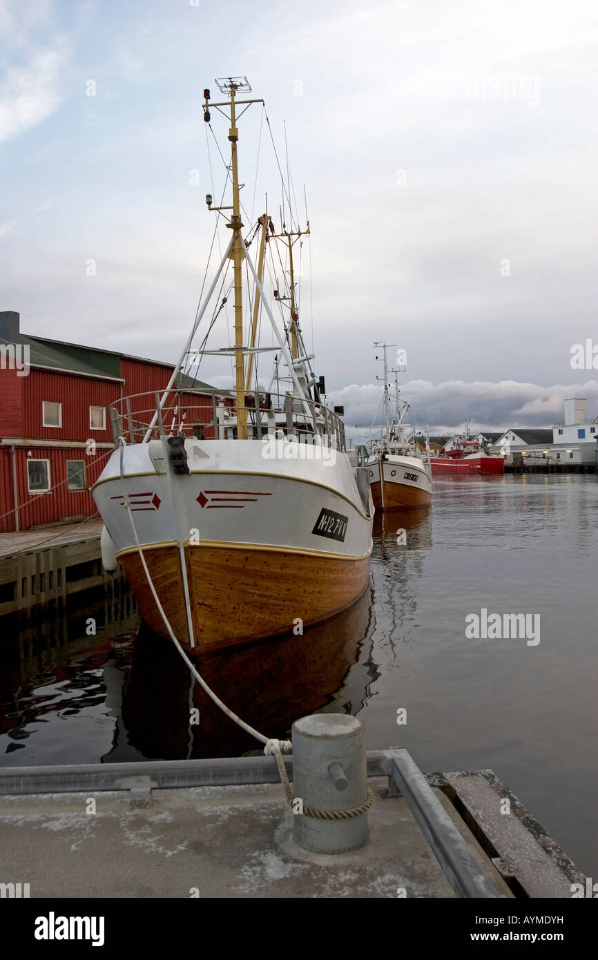 Fishing boat alongside old wooden quay at Ballstad, Lofoten, Norway ...