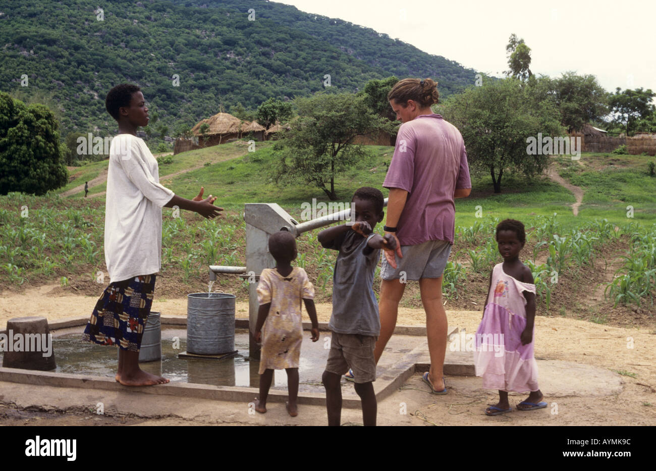 Villager explaining to a westerner how to use the water pump in the ...
