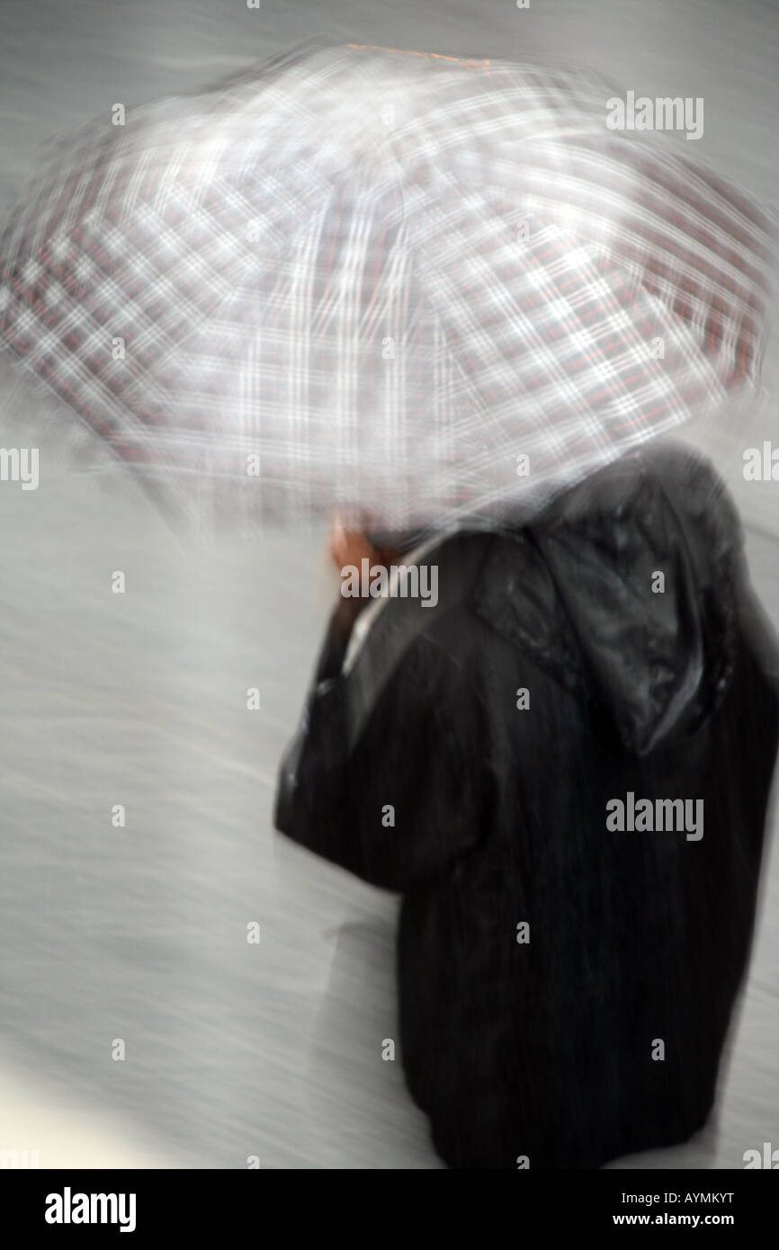 person with umbrella walking in rain in town Stock Photo - Alamy