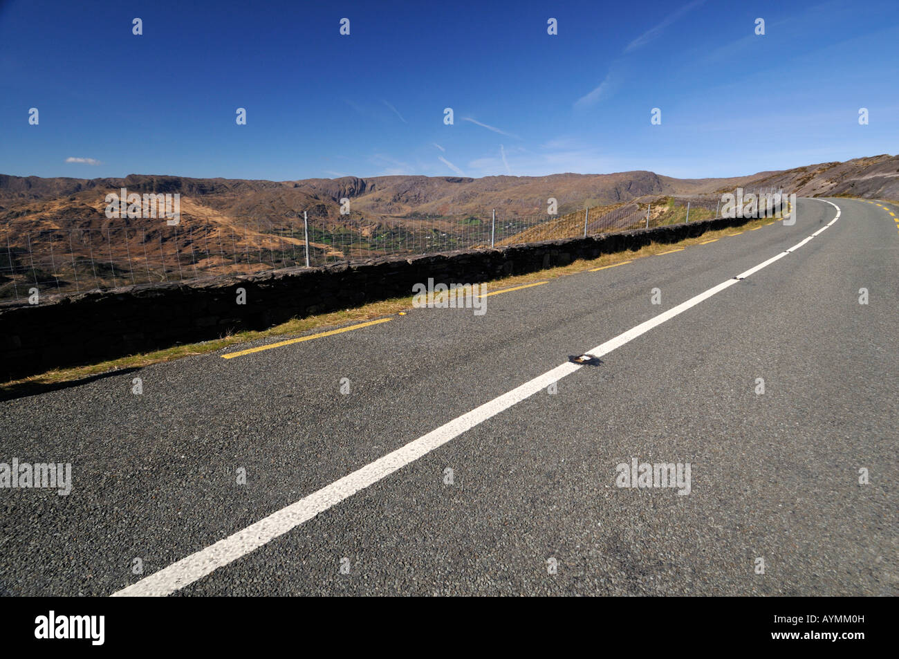 Continuous white line along an empty stretch of road with a sweeping ...