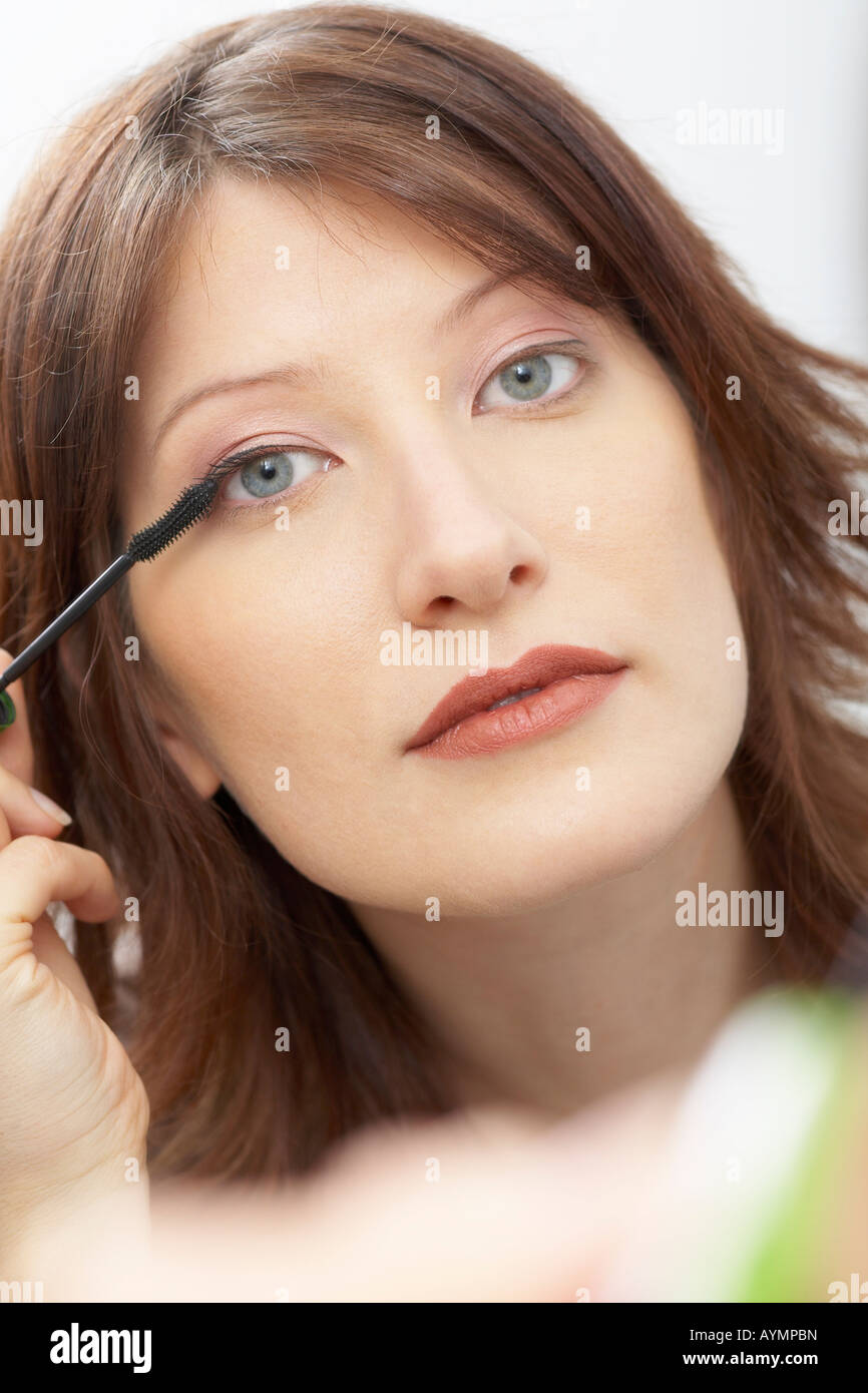 Portrait of a woman applying mascara Stock Photo - Alamy
