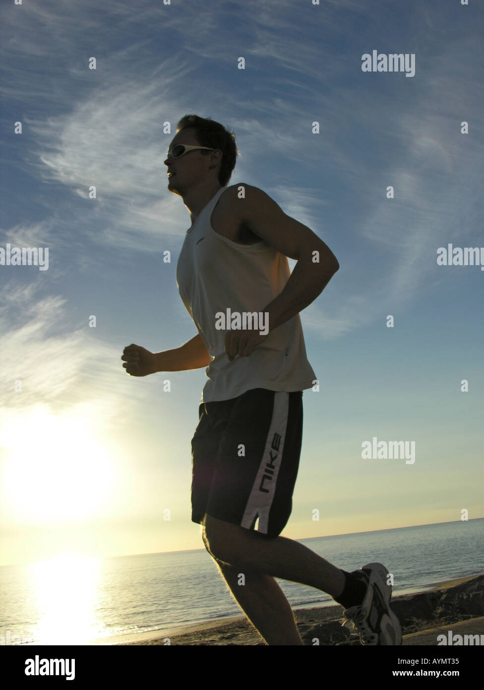 Man running along sea Stock Photo - Alamy