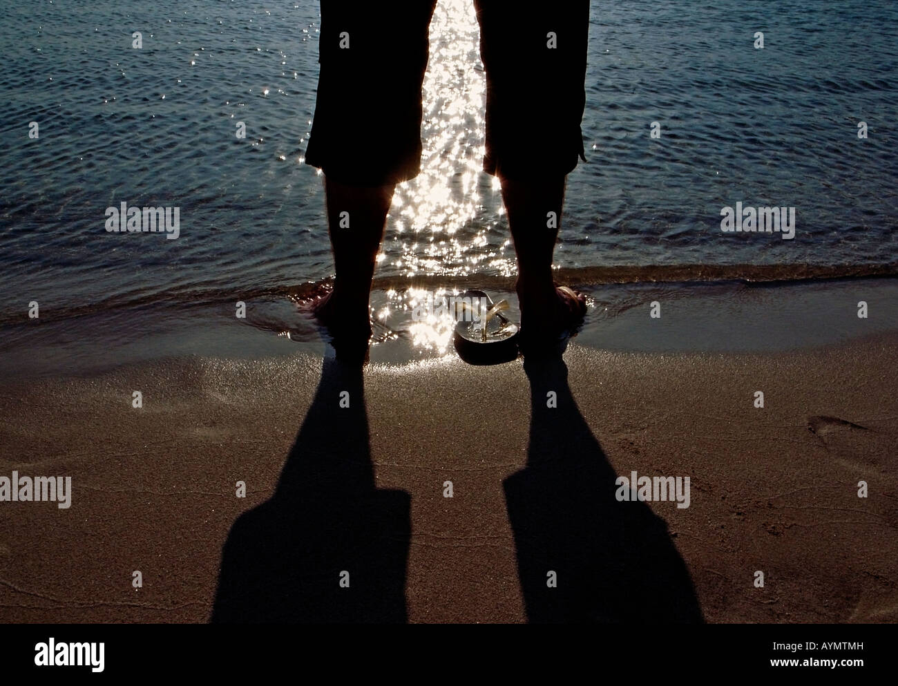 feet in waters edge, ocean sunset Stock Photo - Alamy