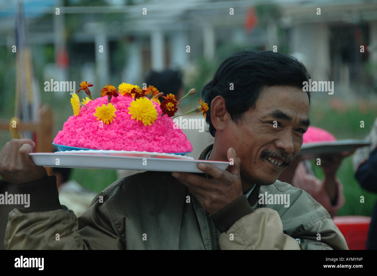 A farmer carries his offering of rice at a ceremony to give thanks at ...