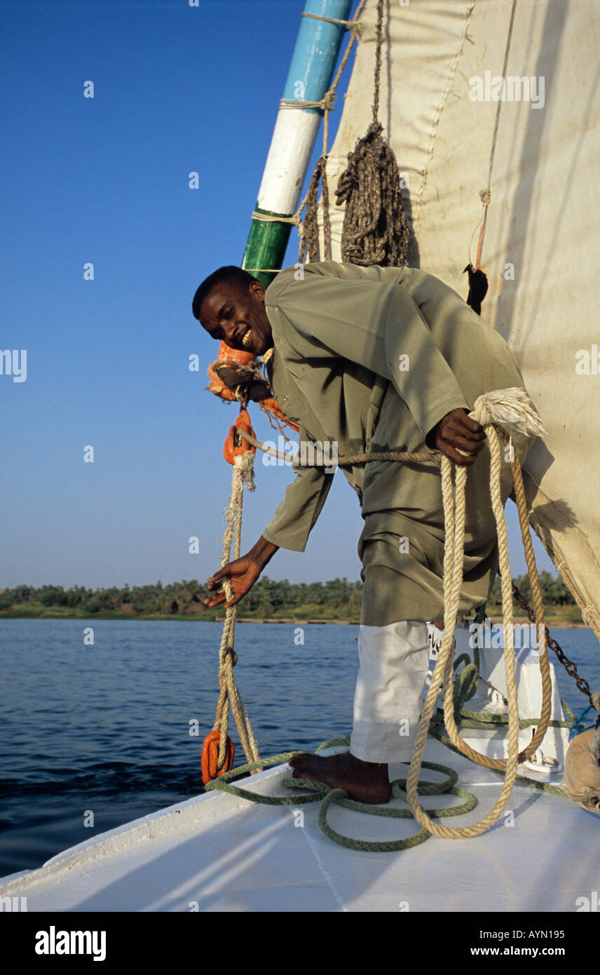 Egyptian felucca sailor takes in sails onboard River Nile cruise Egypt ...