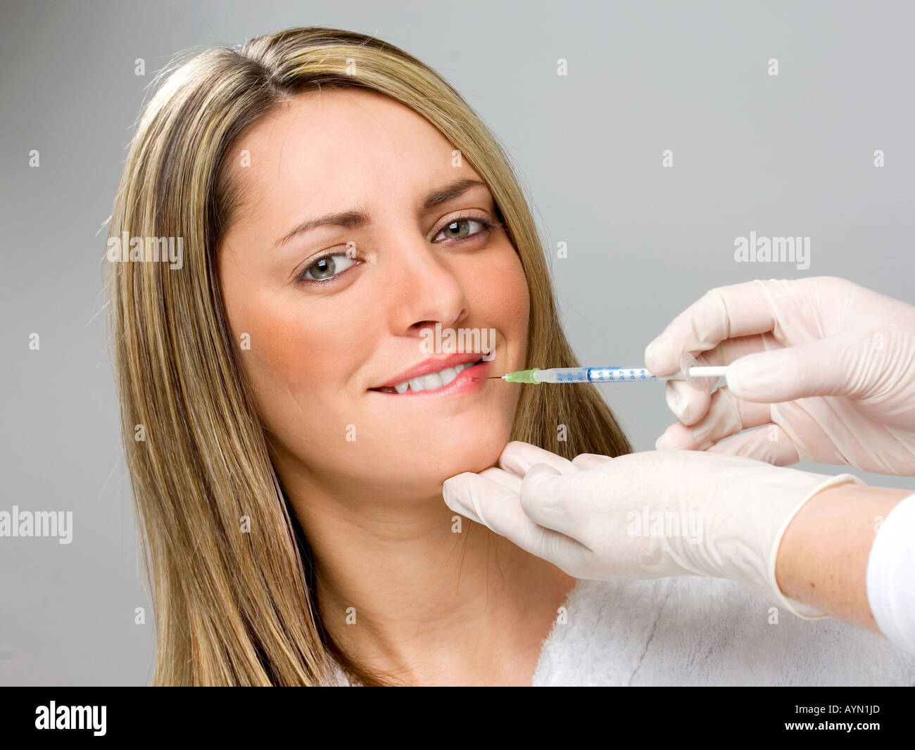 woman receiving botox injection in lip looking anxious Stock Photo - Alamy