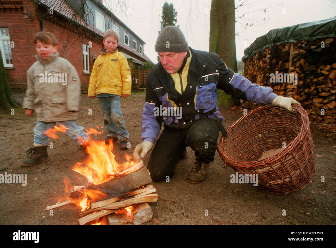 Father and sons making fire Stock Photo - Alamy