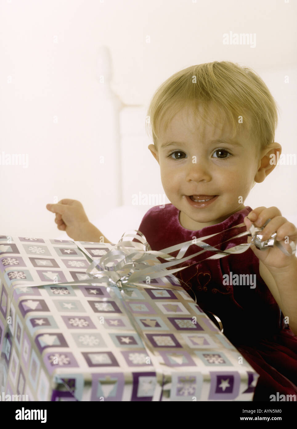 Smiling baby girl opening a Christmas present Stock Photo - Alamy