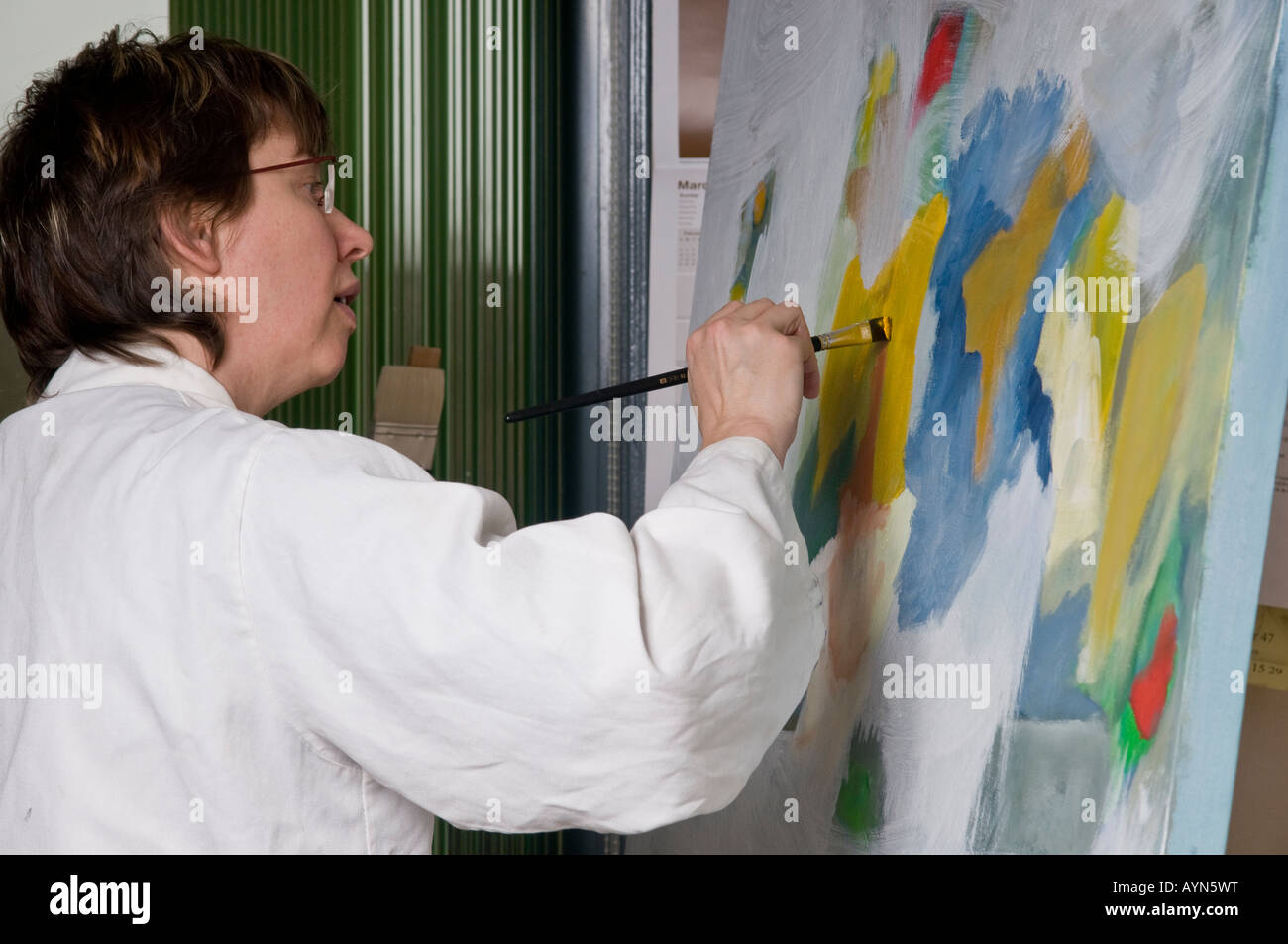 woman painting modern style art in studio on canvas with smock on Stock ...