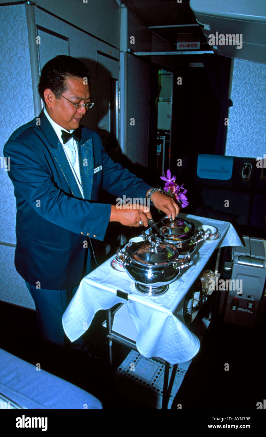 Cabin crew member preparing 1st class meal on Malaysian Airlines Boeing ...