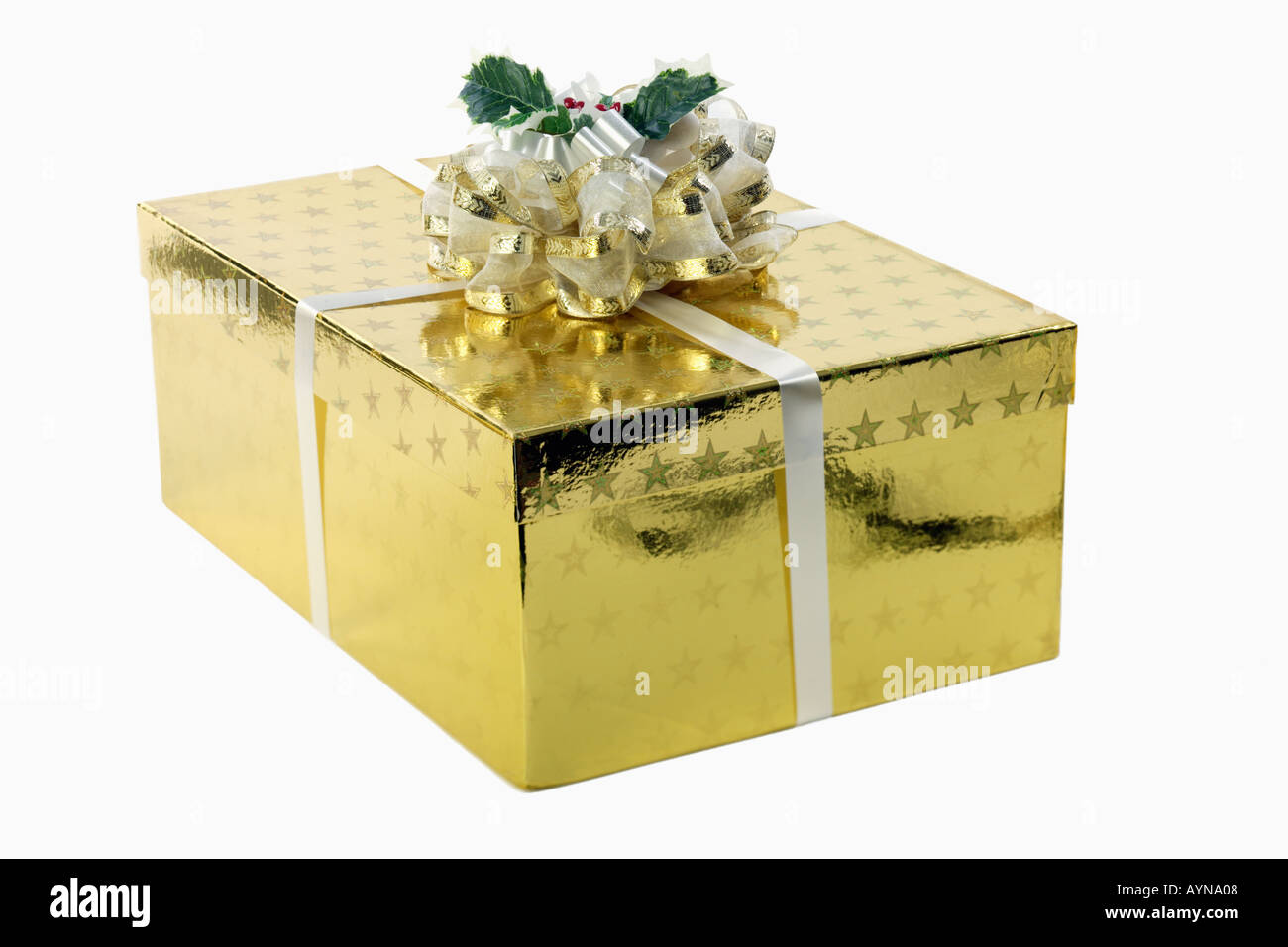 Still life of a shiny gold gift wrapped present with an ornate red bow ...